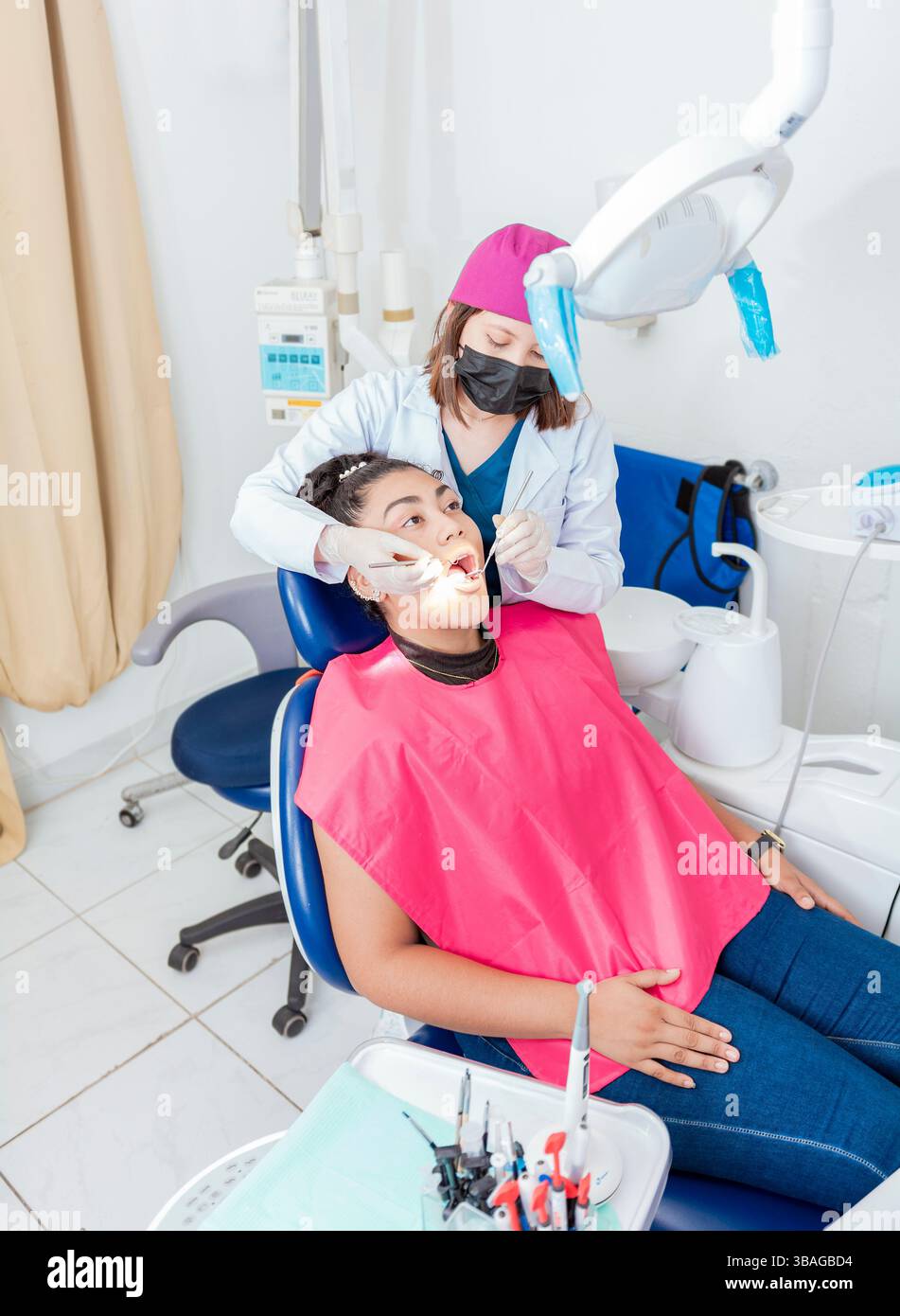 Dentist in his office examining female patient's mouth. Female dentist ...