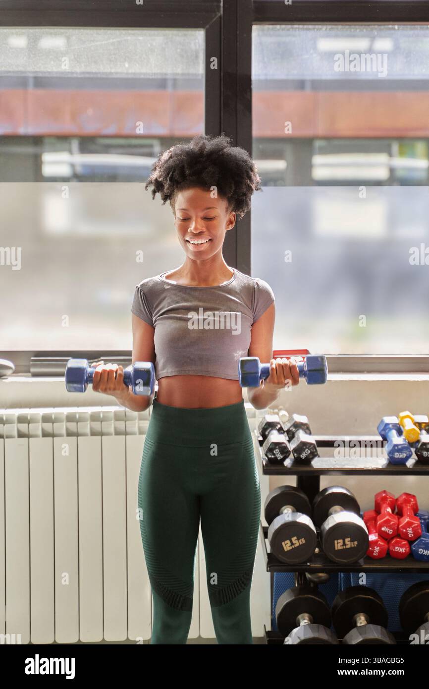 African woman doing sports with weights in the gym Stock Photo - Alamy