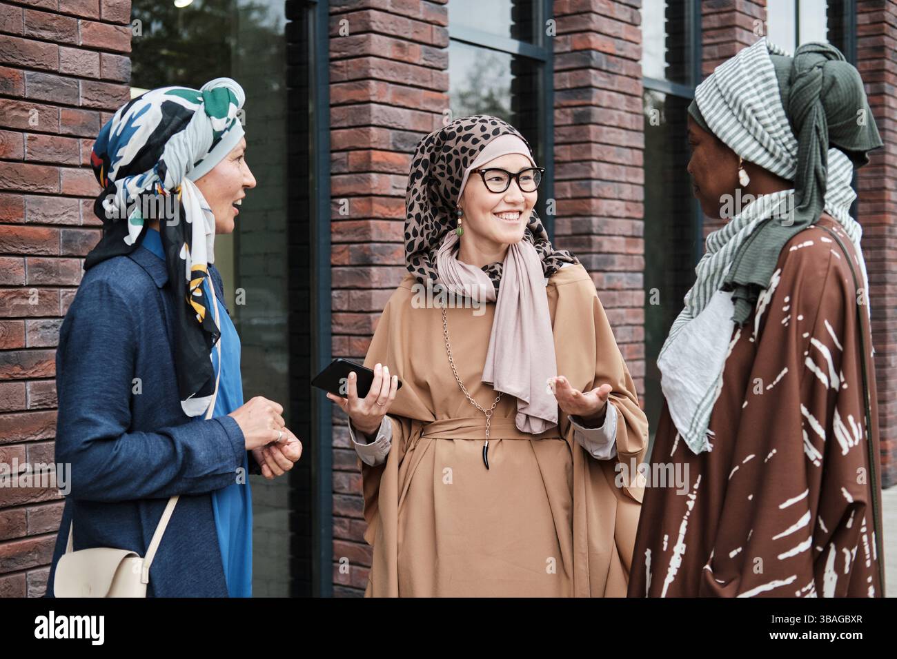 Happy muslim women in traditional clothing meeting together in the city ...