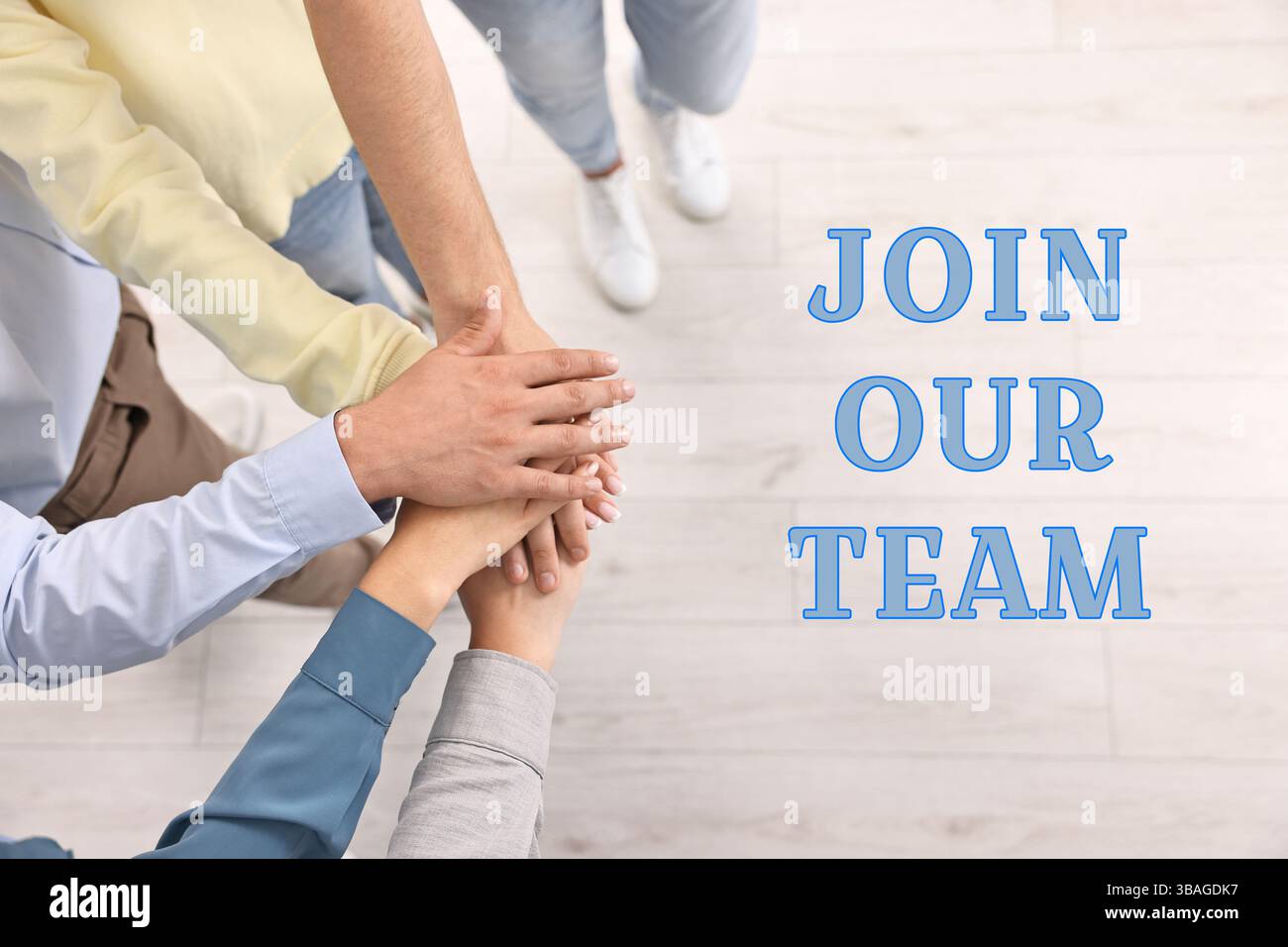Join Our Team. Group of employees joining hands in office, top view ...