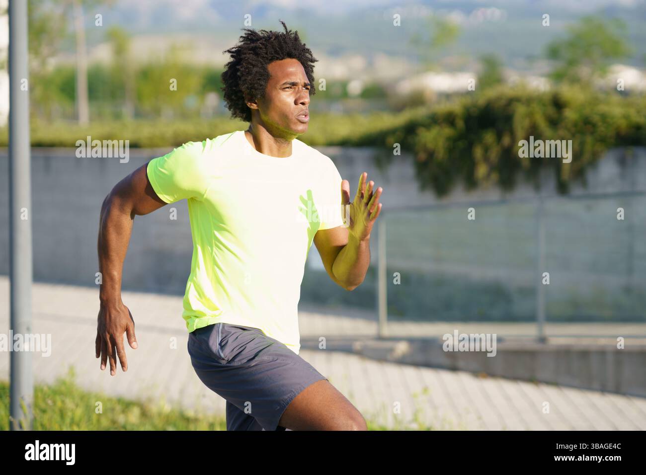 Black athletic man, afro hairstyle, running in an urban park. Young ...