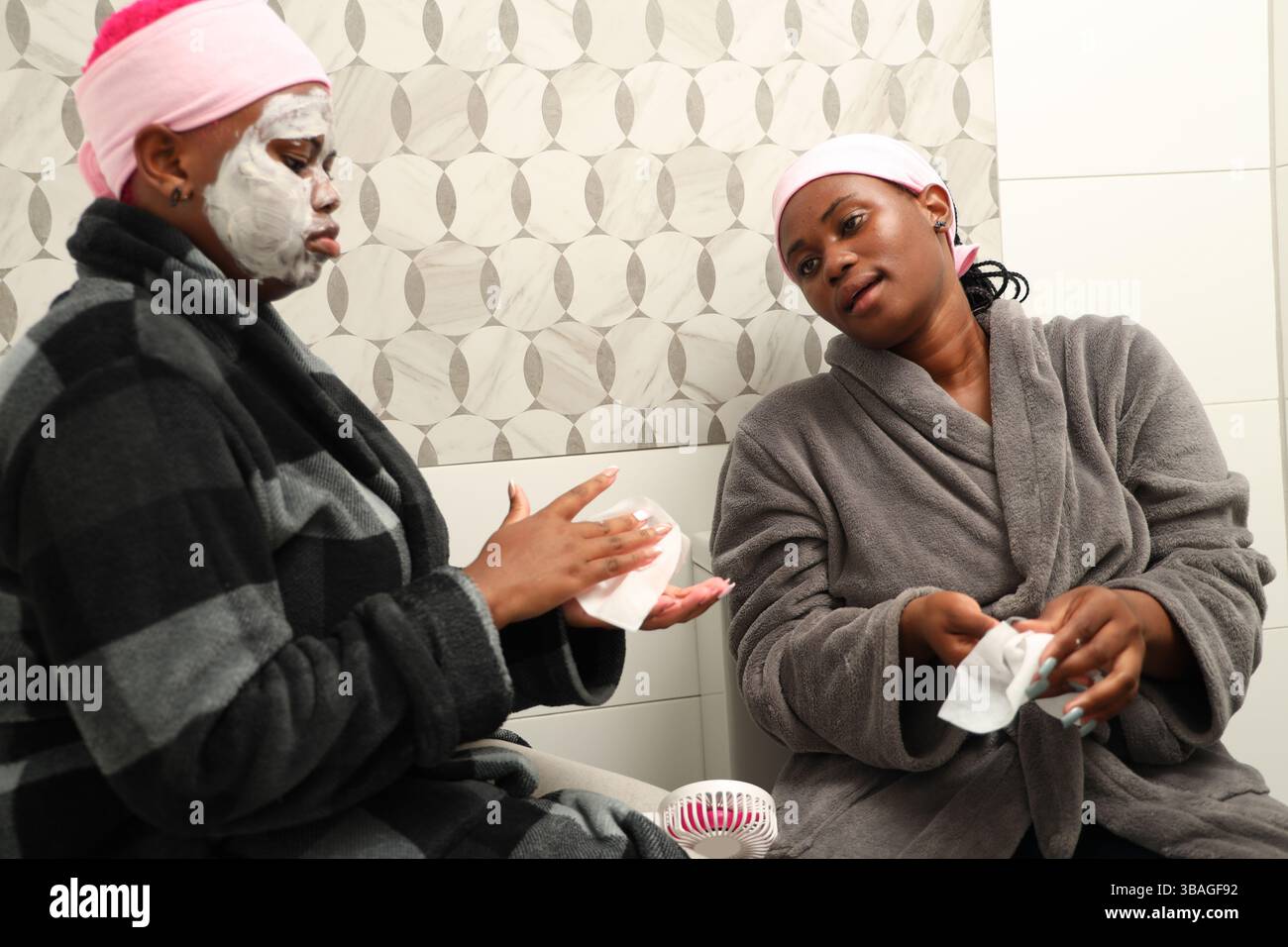 Black teen female and woman talking to each other wiping both hands ...