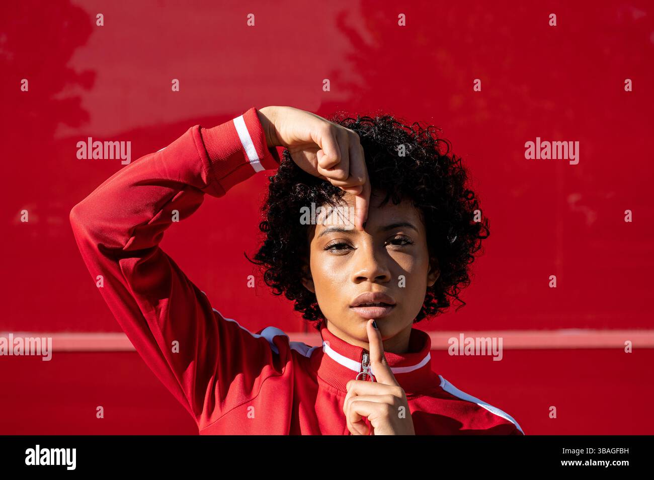African American female with fingers on forehead and below lips ...