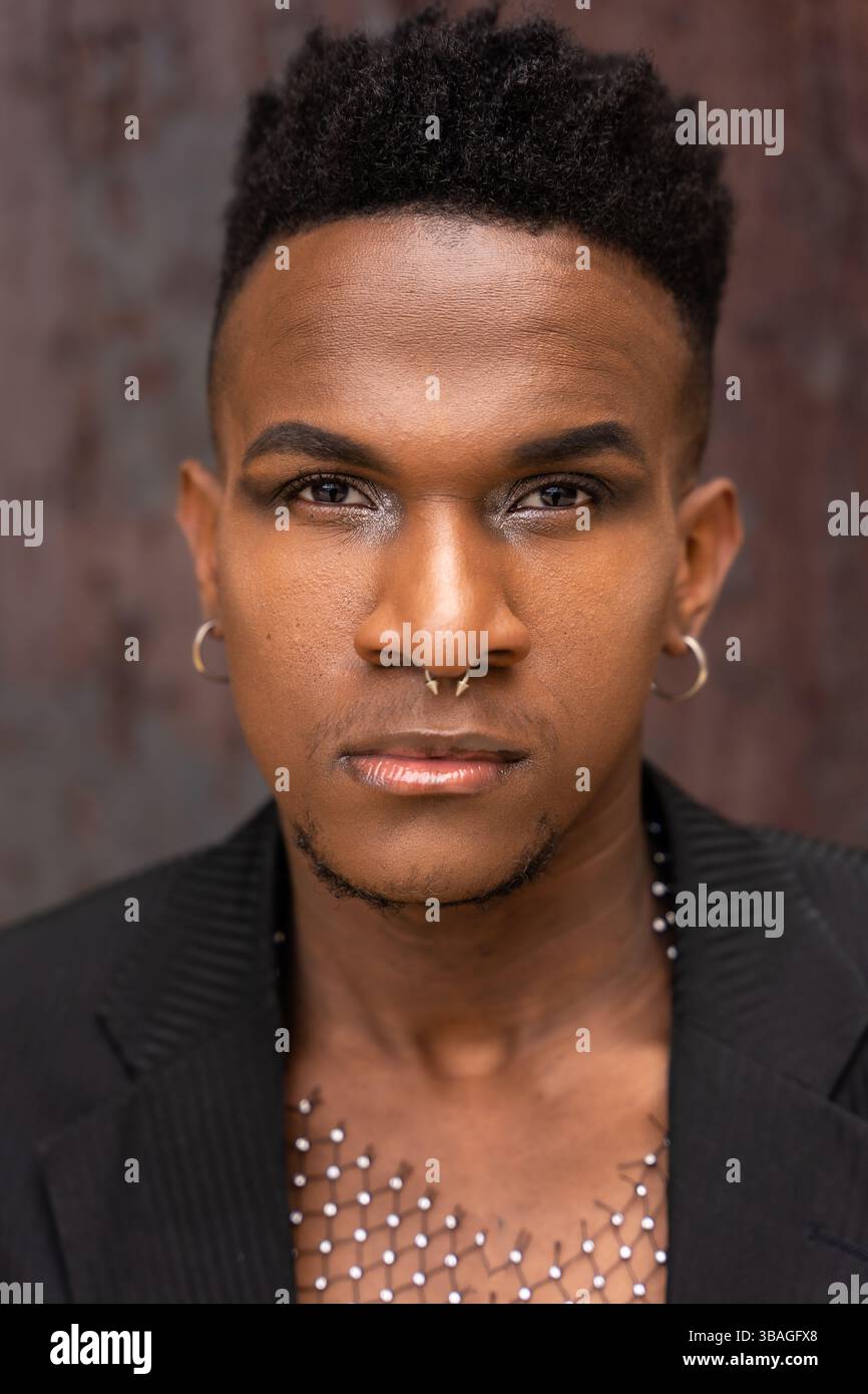 Portrait of a black ethnic man in a fashion pose on a metallic ...