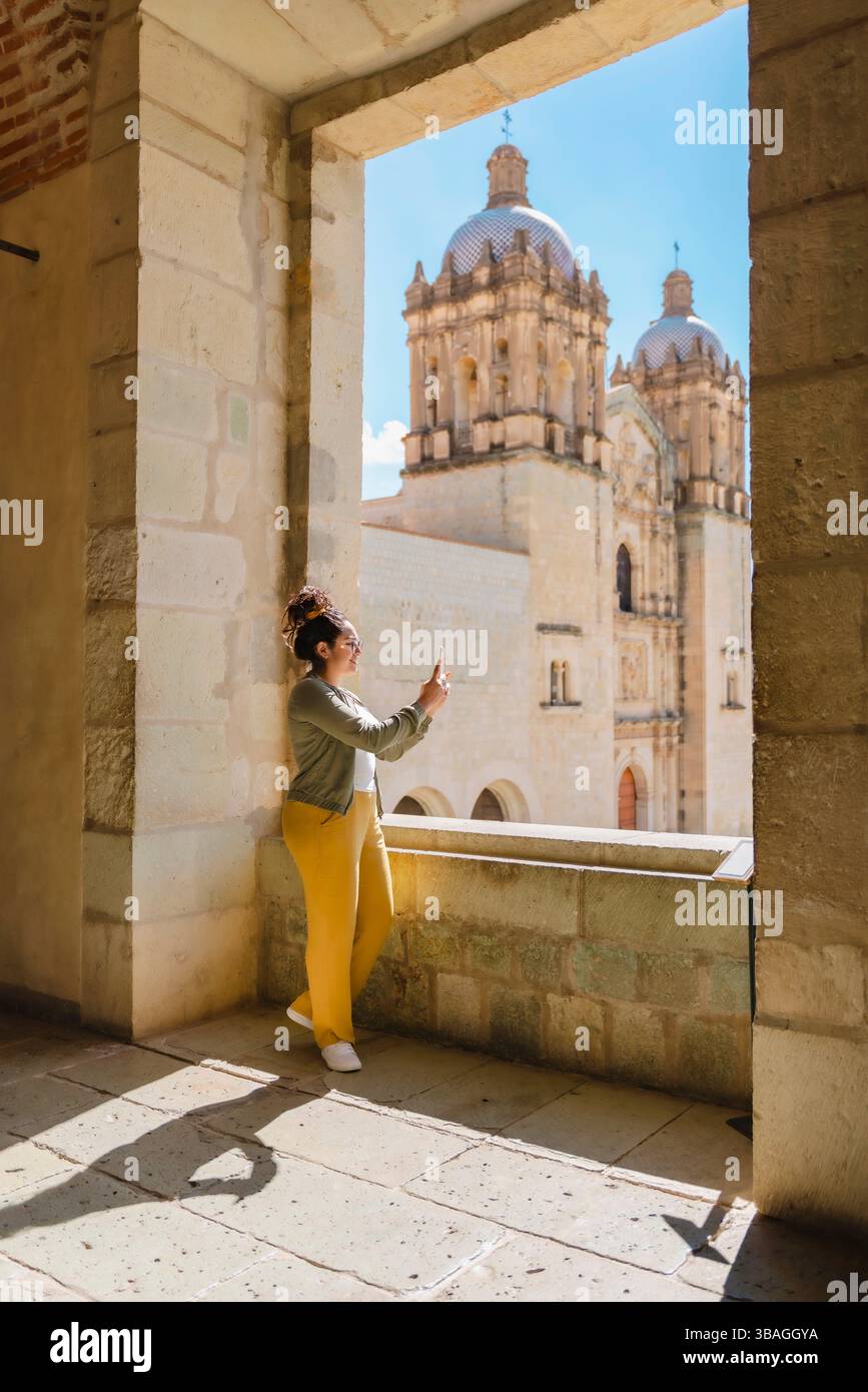 Hispanic female tourist taking photo of the architecture while standing ...
