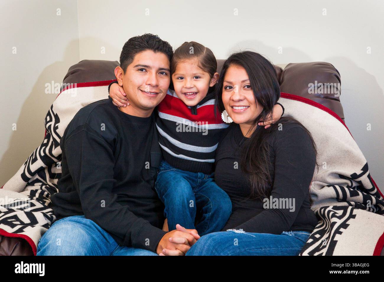 Happy Native American family snuggle together while sitting in an ...