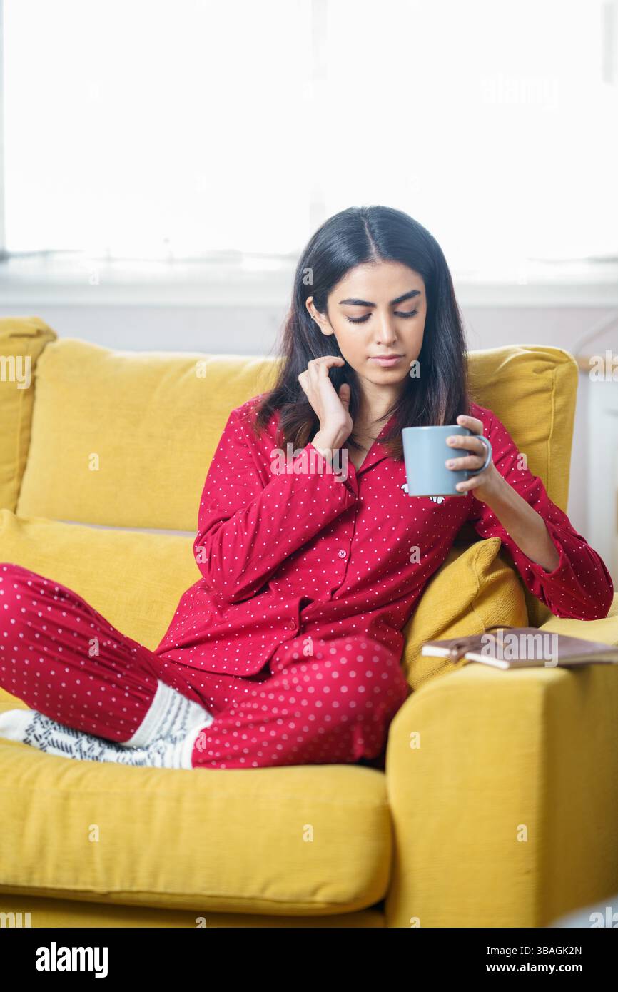 Persian woman at home having tea and reading Stock Photo - Alamy
