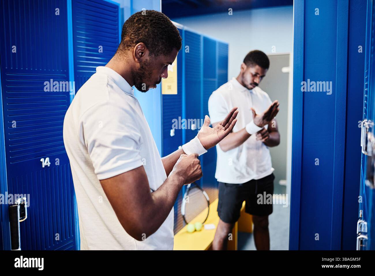 Serious African American man adjusting wristbands while standing in ...