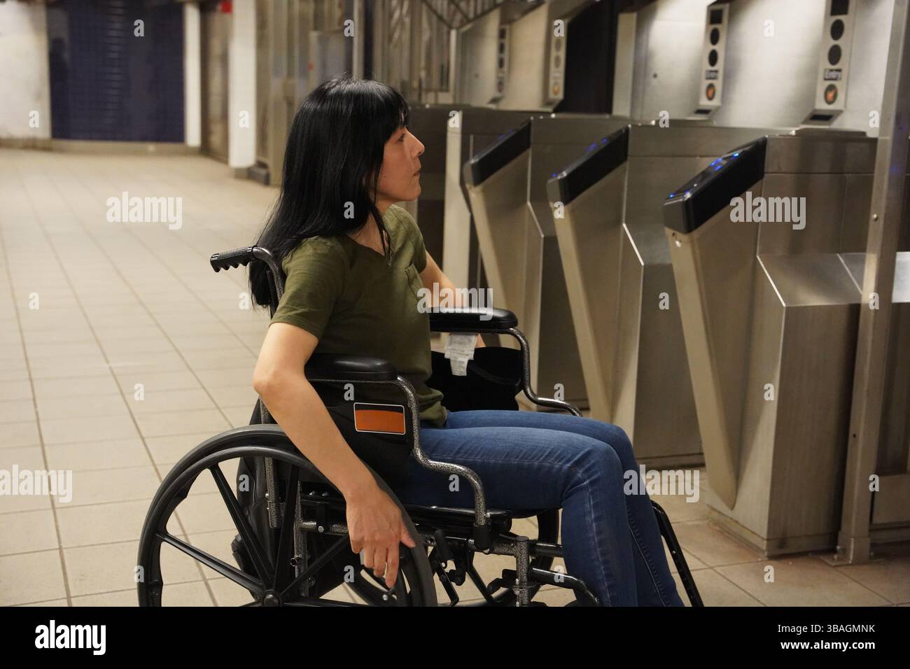Disabled Asian woman in wheelchair entering gate in train station Stock ...