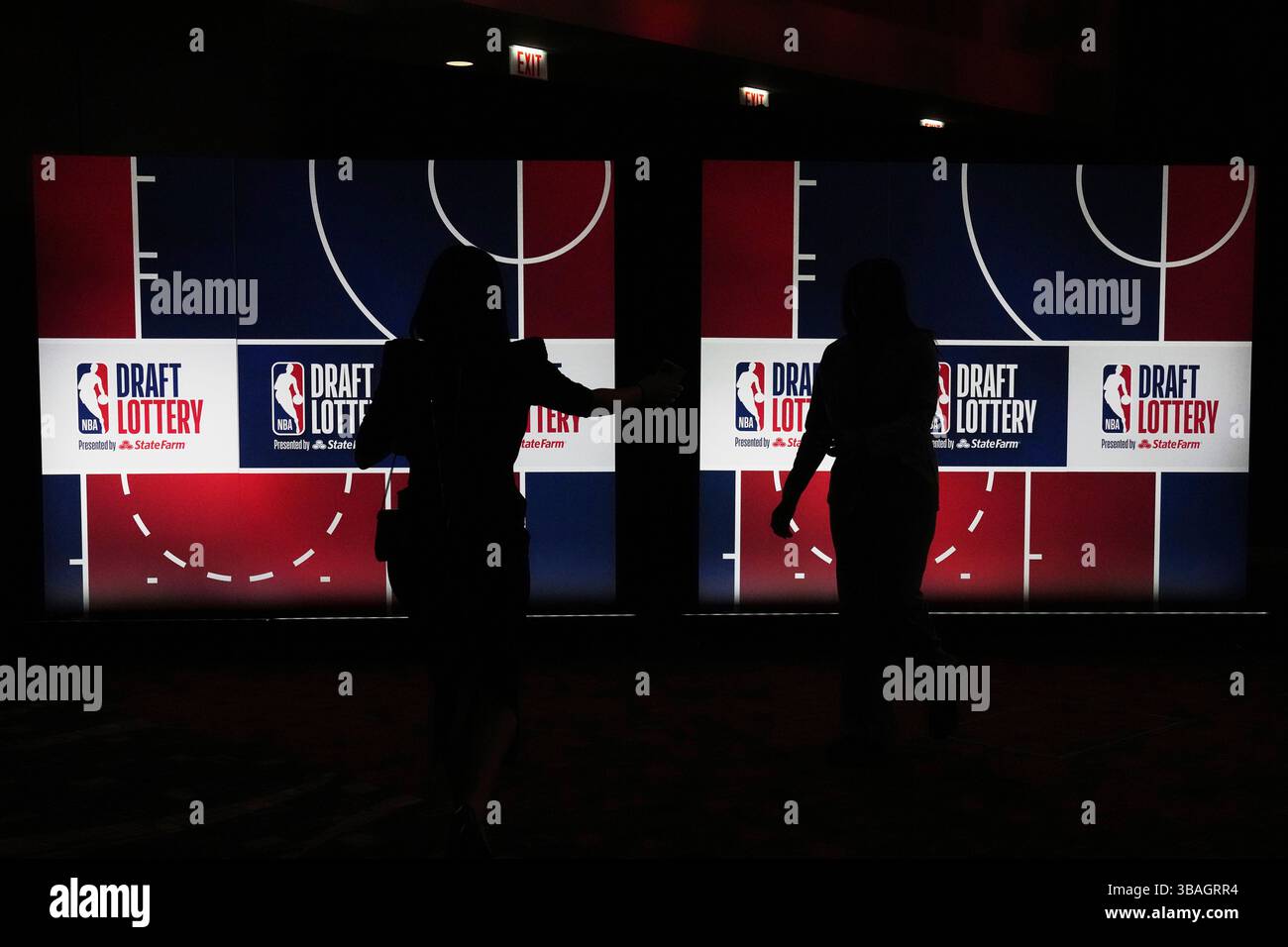 People walk by a sign in the NBA basketball draft lottery in Chicago ...