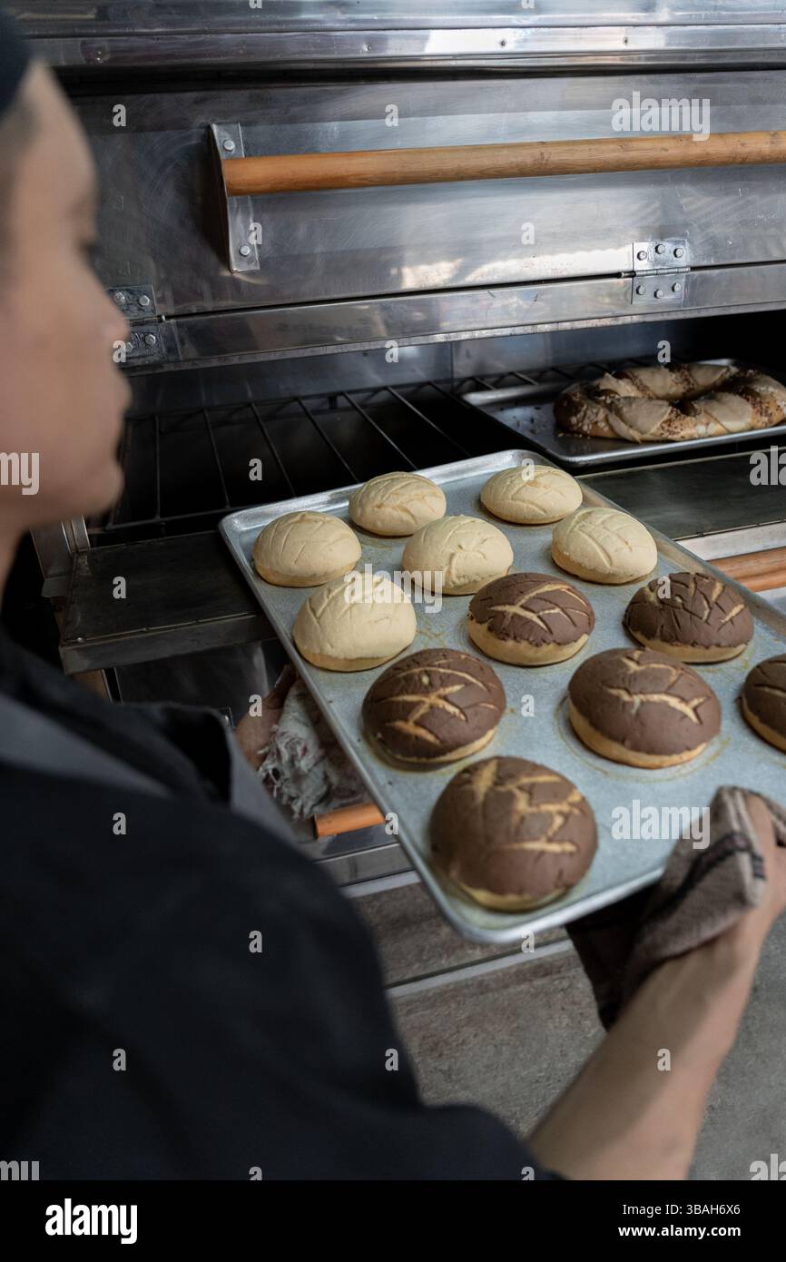 Hispanic baker pulling Mexican chocolate and vanilla shells out of the ...