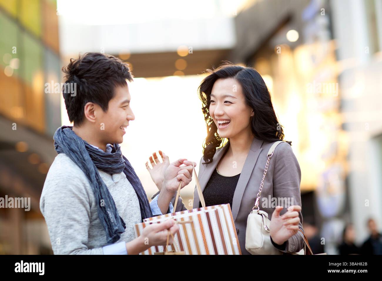 Excited young Chinese woman receiving a surprise gift from boyfriend ...