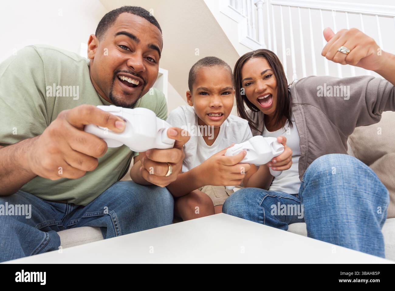 African American family, parents and son, having fun playing computer ...