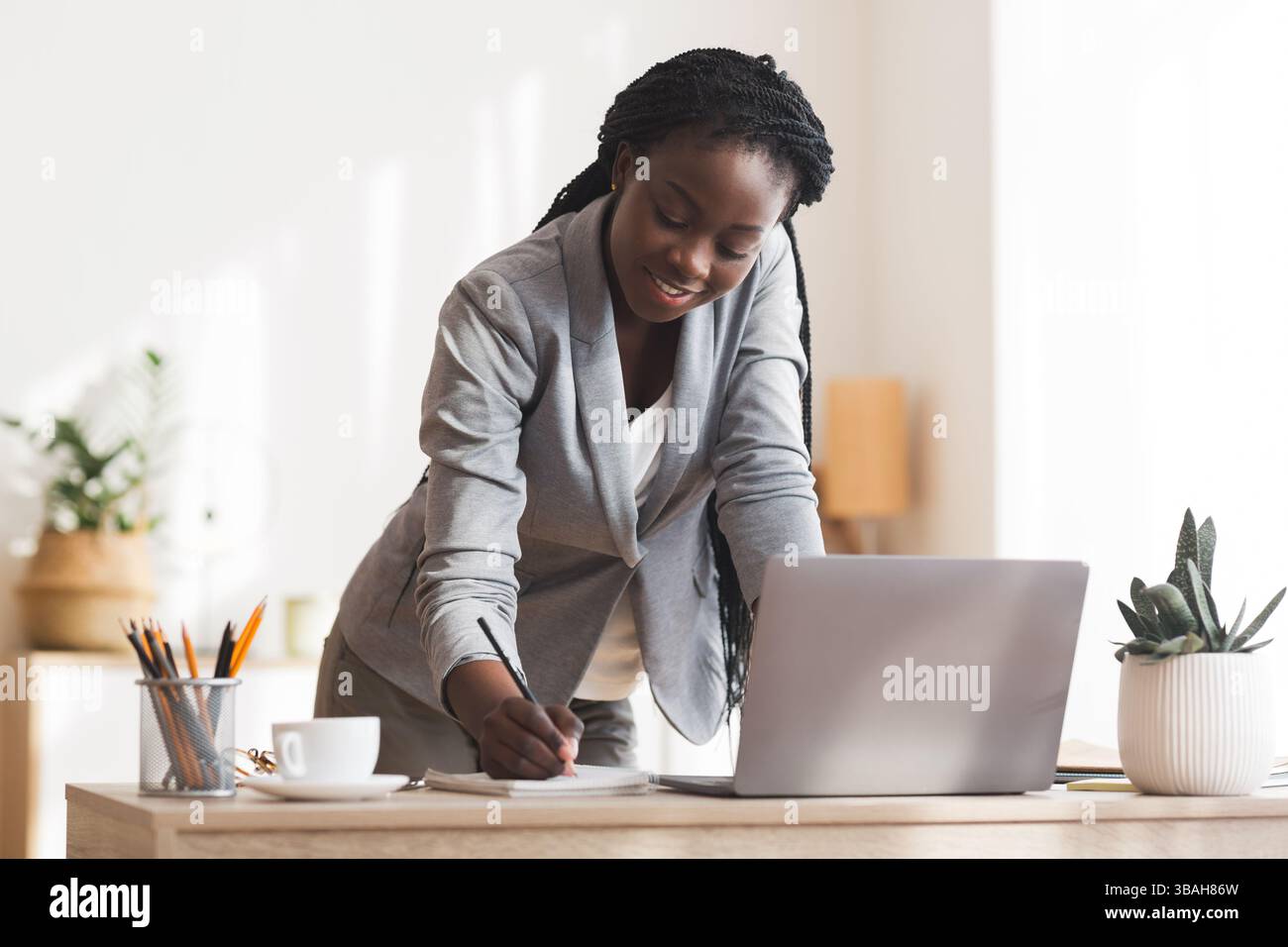 Working process. Busy afro secretary taking notes while standing up ...