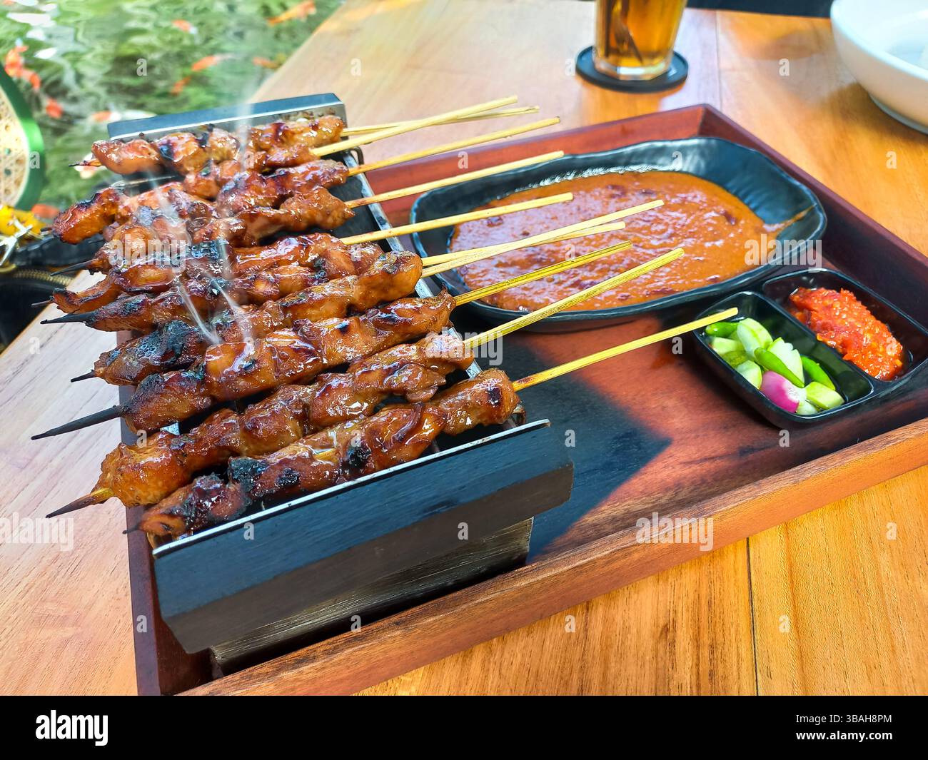 Indonesian Sate Ayam being grilled with peanut sauce, pickled ...