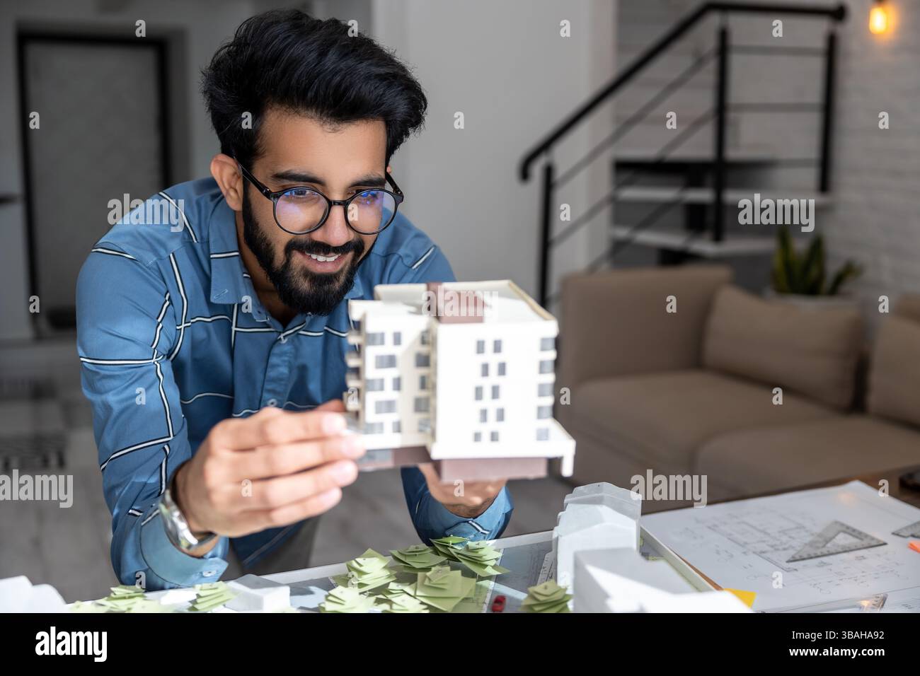 House mock up. Young engineer looking busy and involved while preparing ...