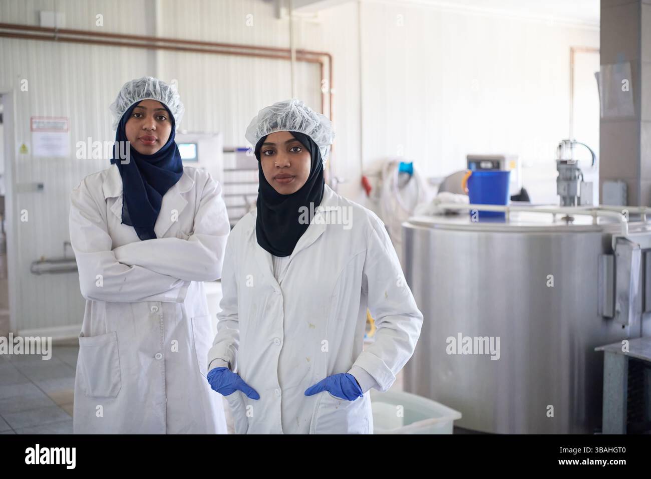 Serious Middle Eastern female factory workers in hijab and white ...