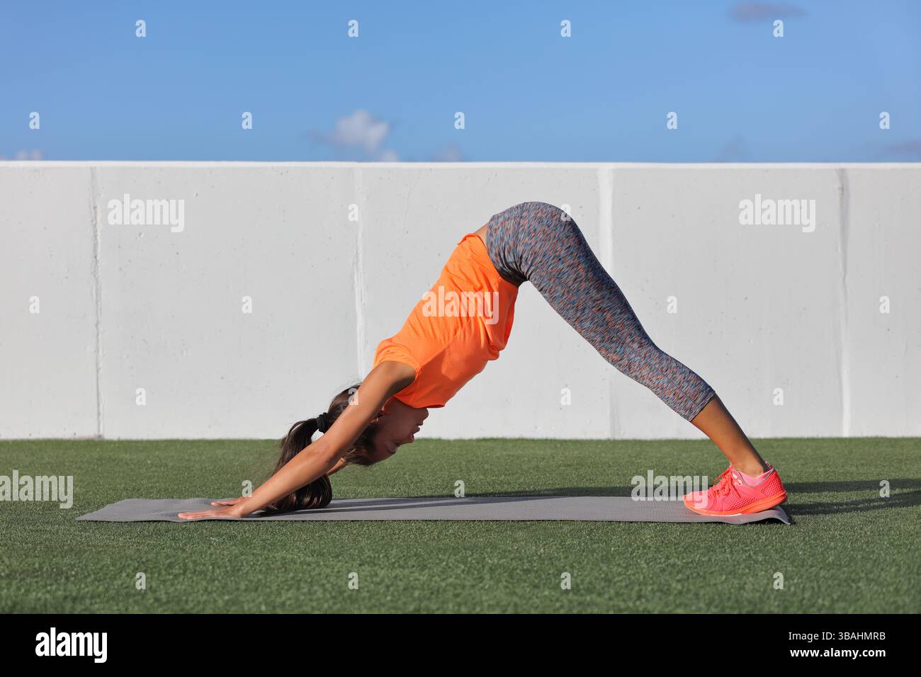 Asian woman doing legs stretch facing downward at outdoor gym Stock ...