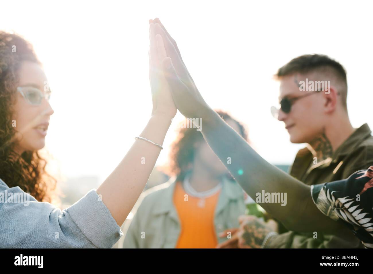 Young intercultural dates giving each other high five against their ...
