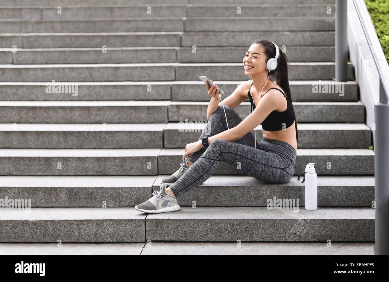 Positive Asian Girl Listening Music On Smartphone While Relaxing After ...