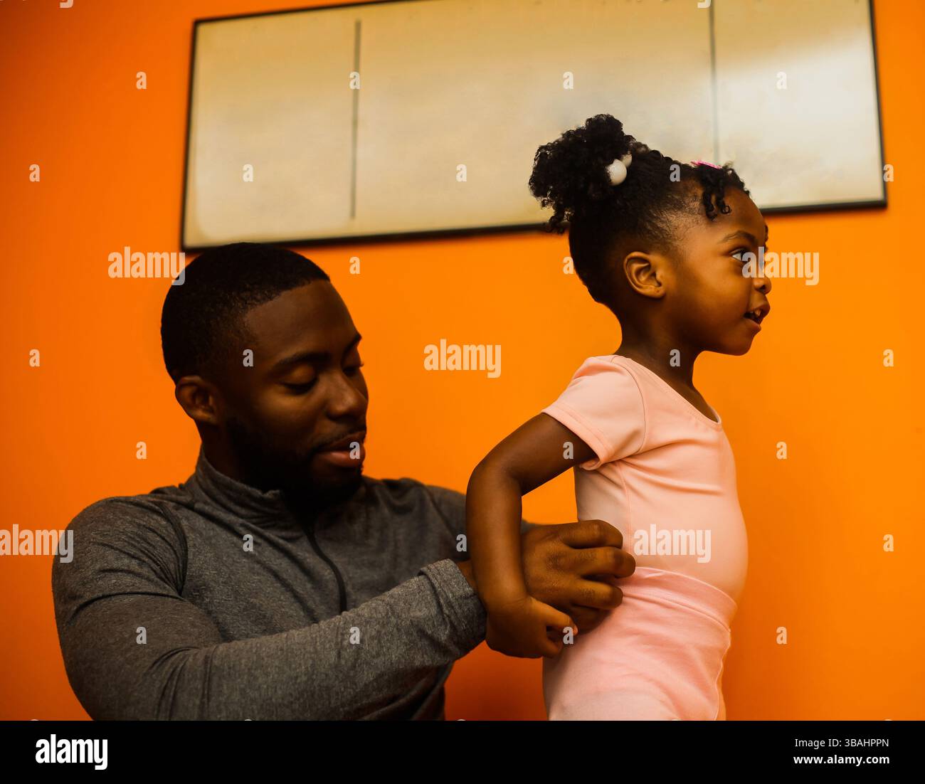 African American father adjusting daughter's leotard Stock Photo - Alamy