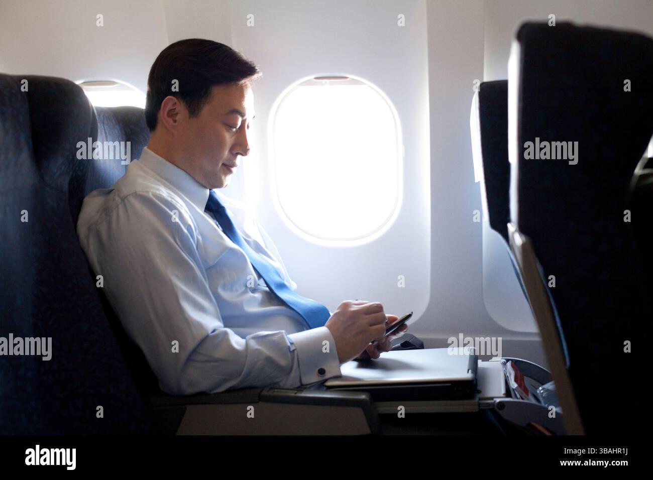 Chinese businessman working on the plane Stock Photo - Alamy