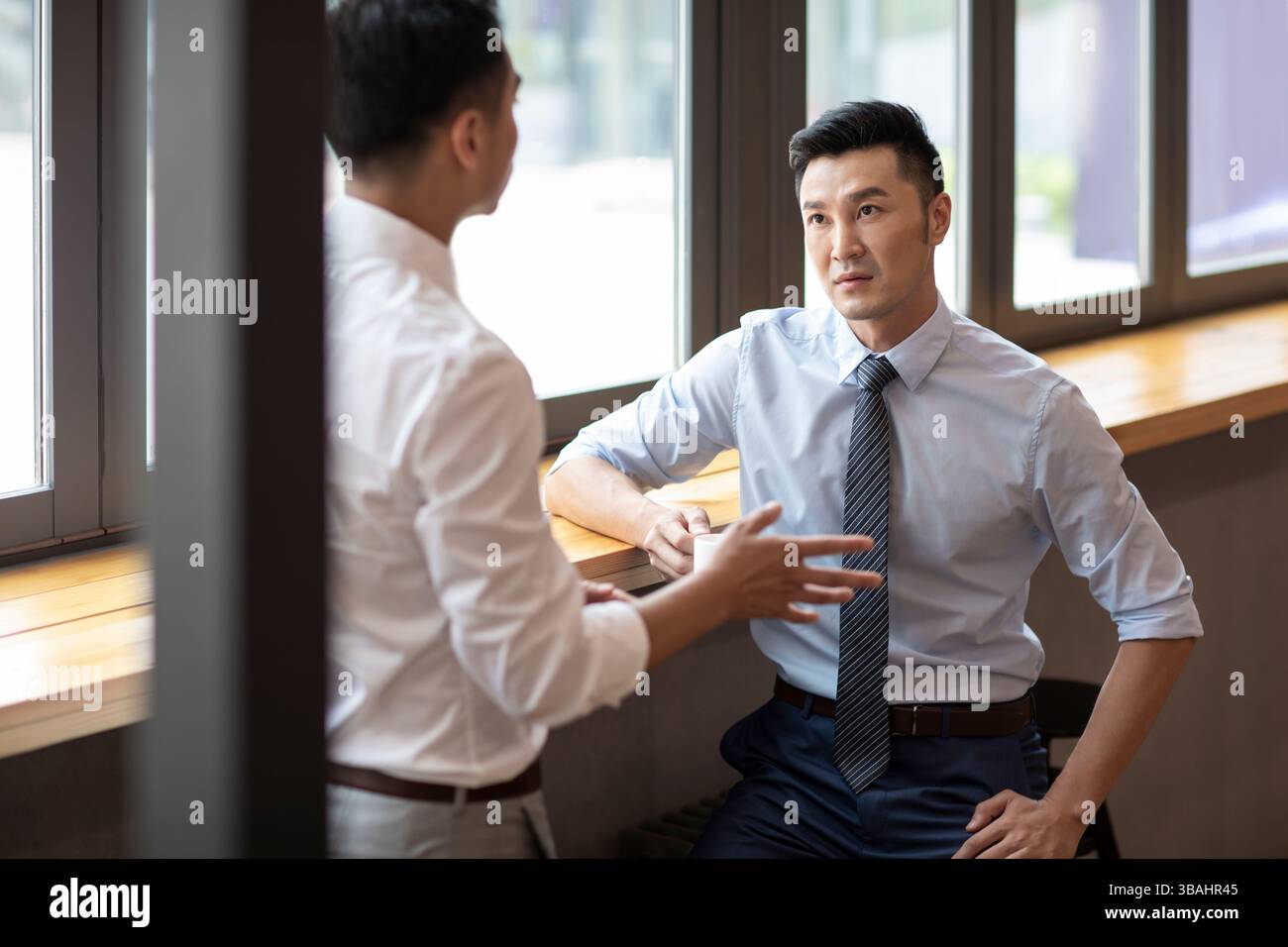 Chinese businessmen talking in cafe Stock Photo - Alamy