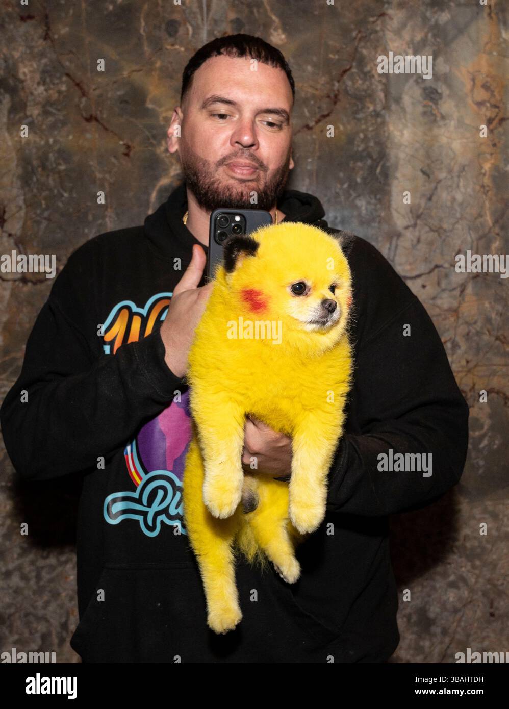 New York, USA. 12th May, 2025. Erik Torres and his dog Zaza dyed yellow ...