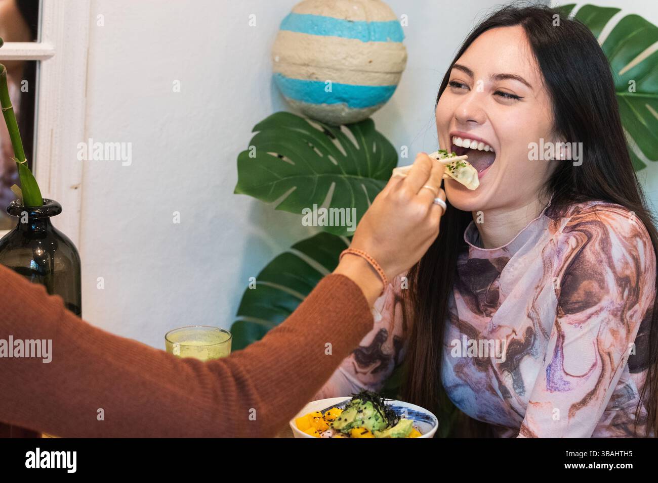 Couple are feeding each other in the restaurant Stock Photo - Alamy
