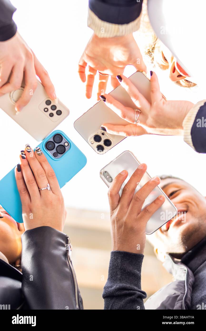 Low angle of group of people holding cellphone. Low angle of group of ...