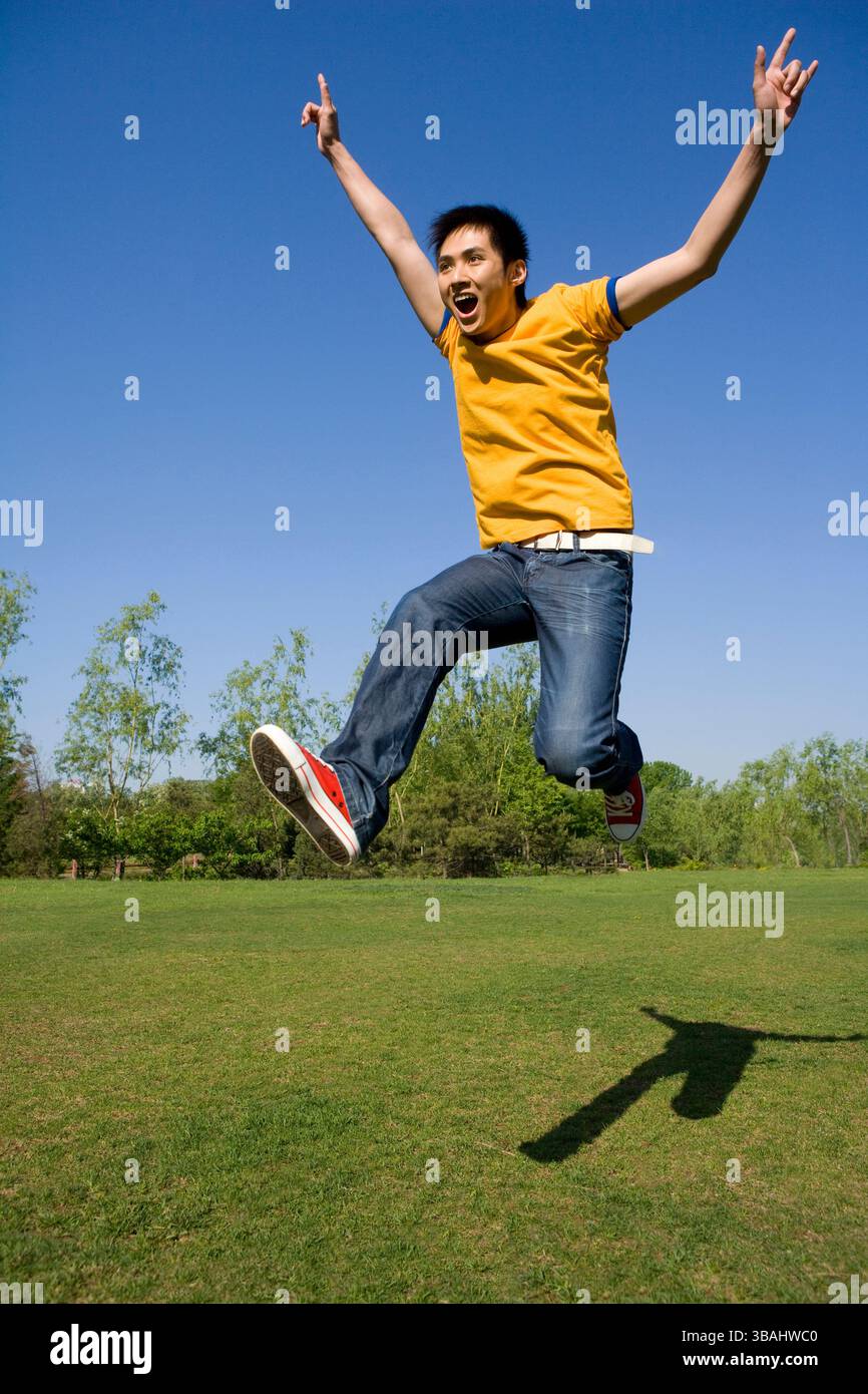 Young Chinese man jumping in air at park Stock Photo - Alamy