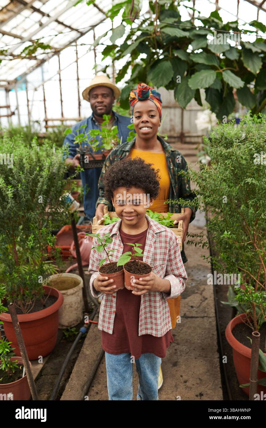 African family of three working together in the garden they planting ...