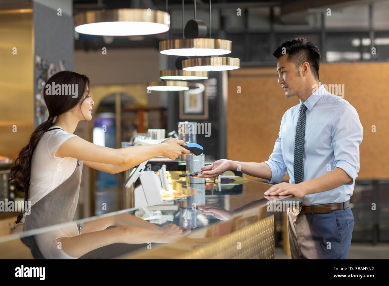 Chinese man pays for his order using smartphone while female cashier ...