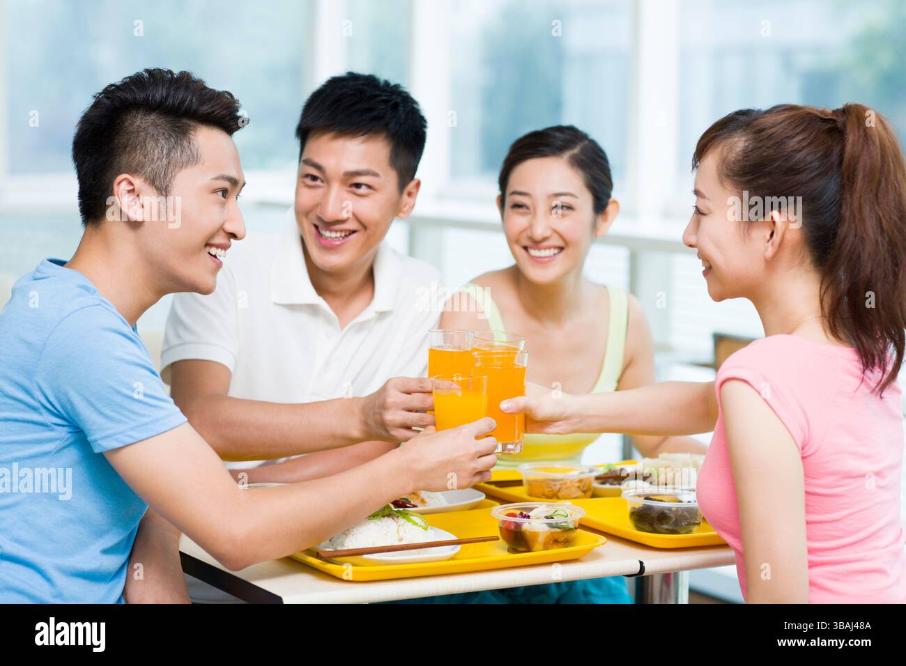Young Chinese adults celebrating with orange juice Stock Photo - Alamy