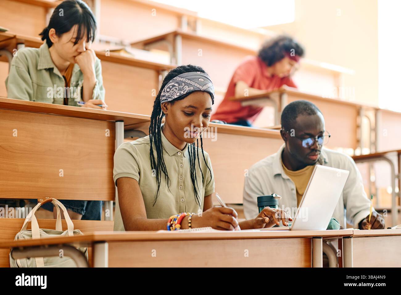 Group of students sitting at desk and studying during lecture at ...