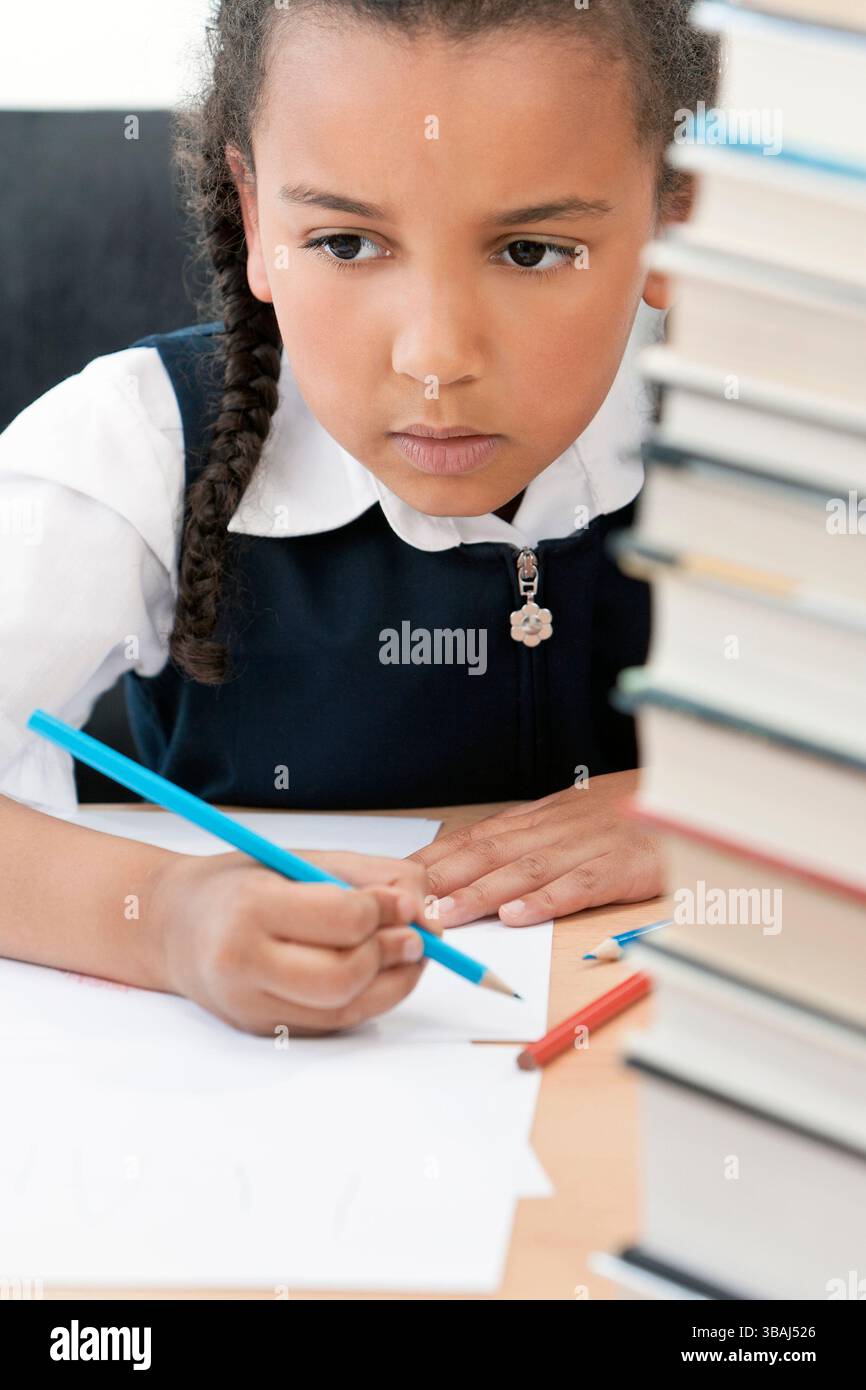 A beautiful young mixed race African American girl writing or drawing ...
