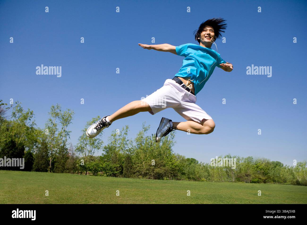 Young Chinese man jumping in air at park Stock Photo - Alamy