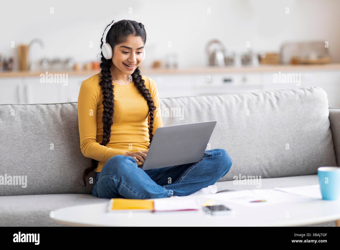Distance Learning. Young Smiling Indian Woman In Wireless Headphones Studying With Laptop At ...