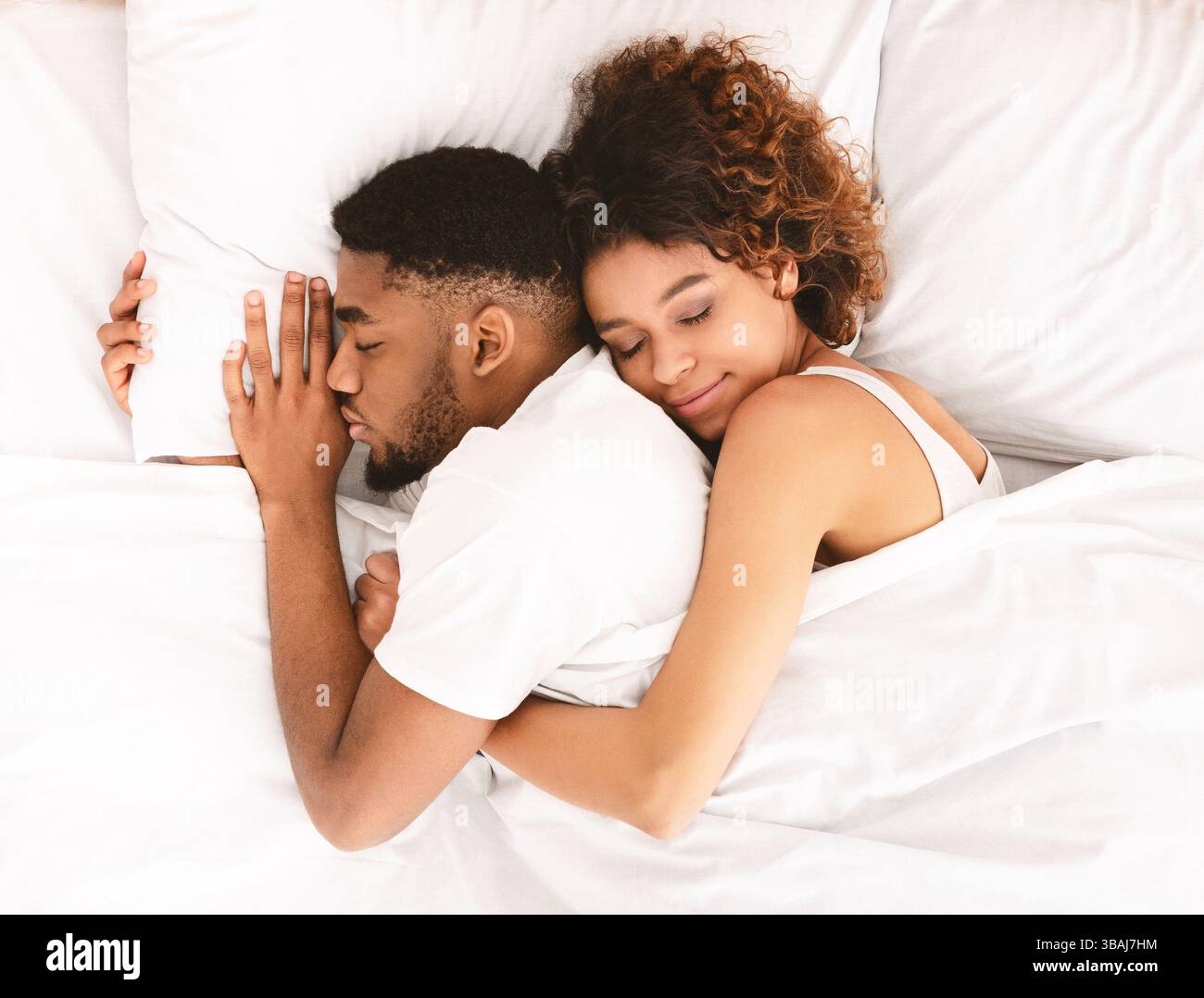 Joint sleep. Happy african-american woman embracing her boyfriend's ...