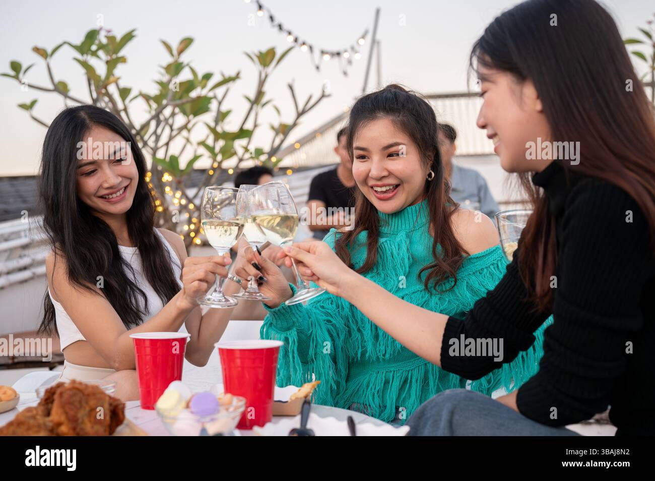 Group of attractive young Asian female friends are toasting champagne ...