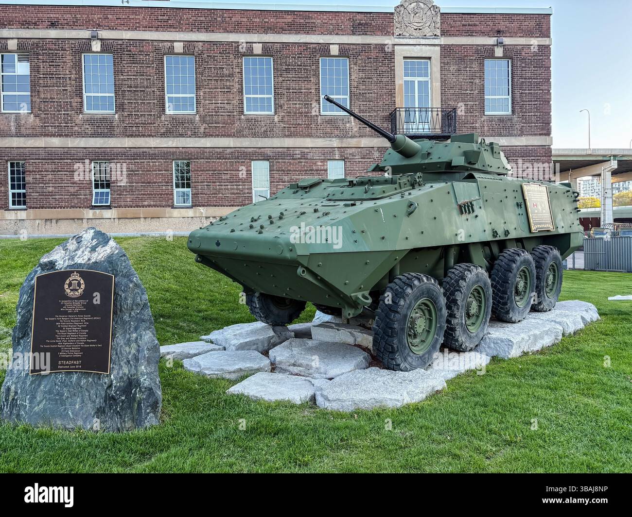 Green armoured military vehicle displayed on stone blocks with a ...