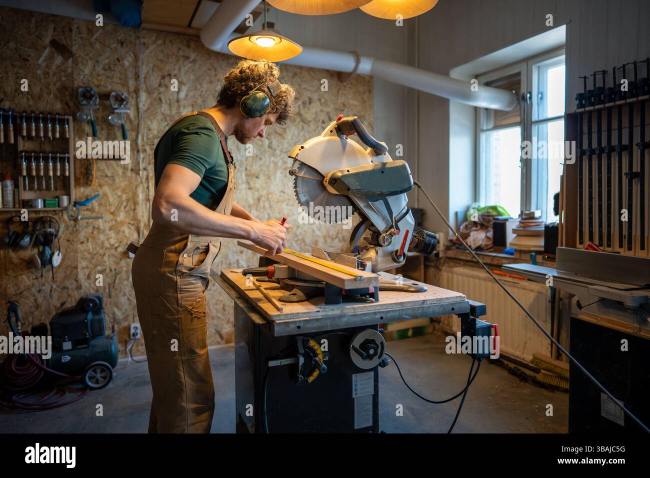 Skilled carpenter use miter saw, measure and trim wood beams in ...