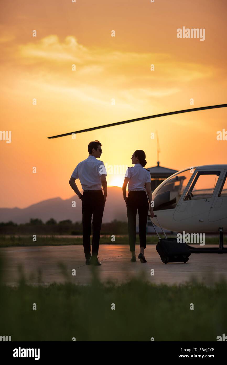 Chinese helicopter pilots walking with luggage Stock Photo - Alamy