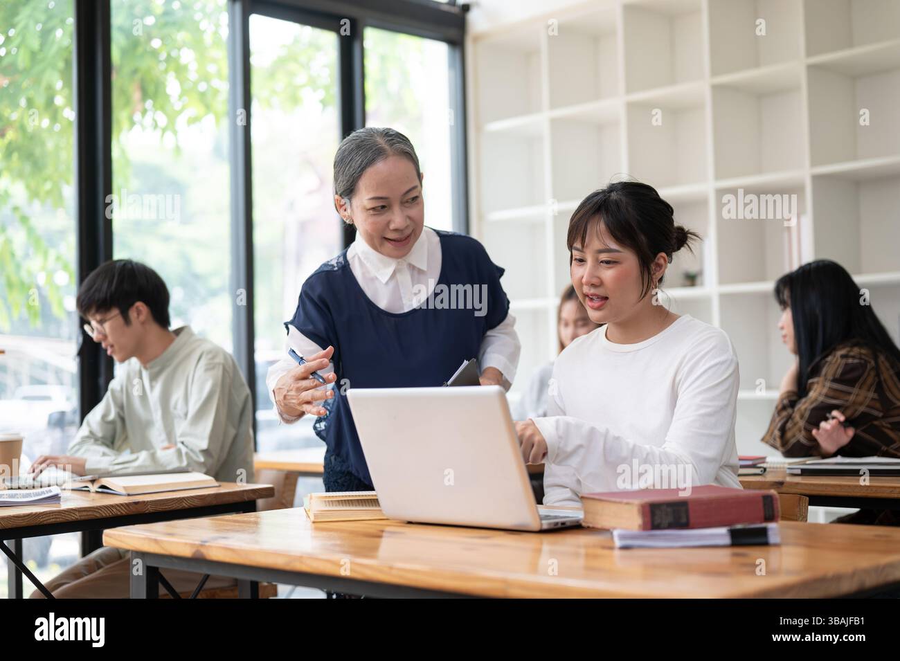 A caring and professional mature Asian female teacher or professor is ...