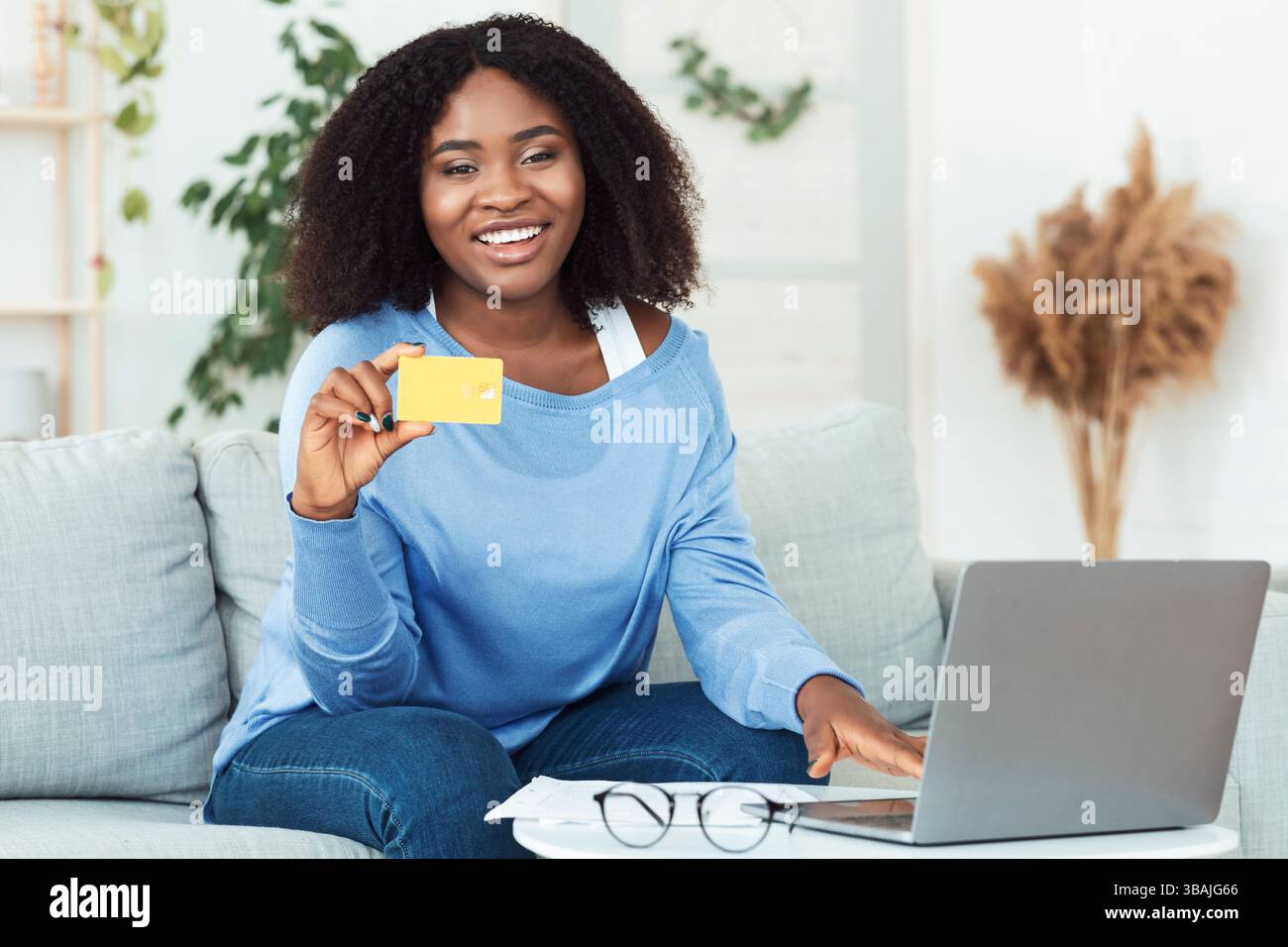 Online Shopping Concept. Happy black woman showing credit card to camera and smiling, using ...