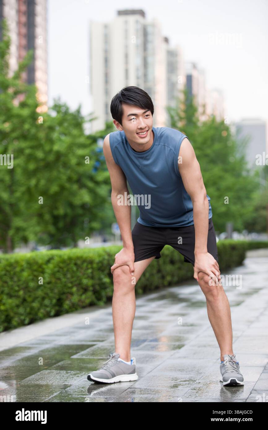 Young Chinese man taking a break from exercise Stock Photo - Alamy