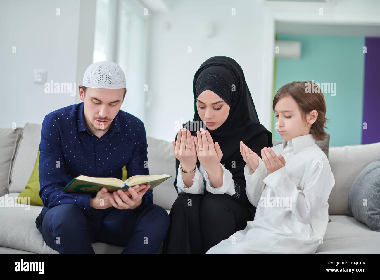 Young muslim family reading Quran during Ramadan. Parents and son ...