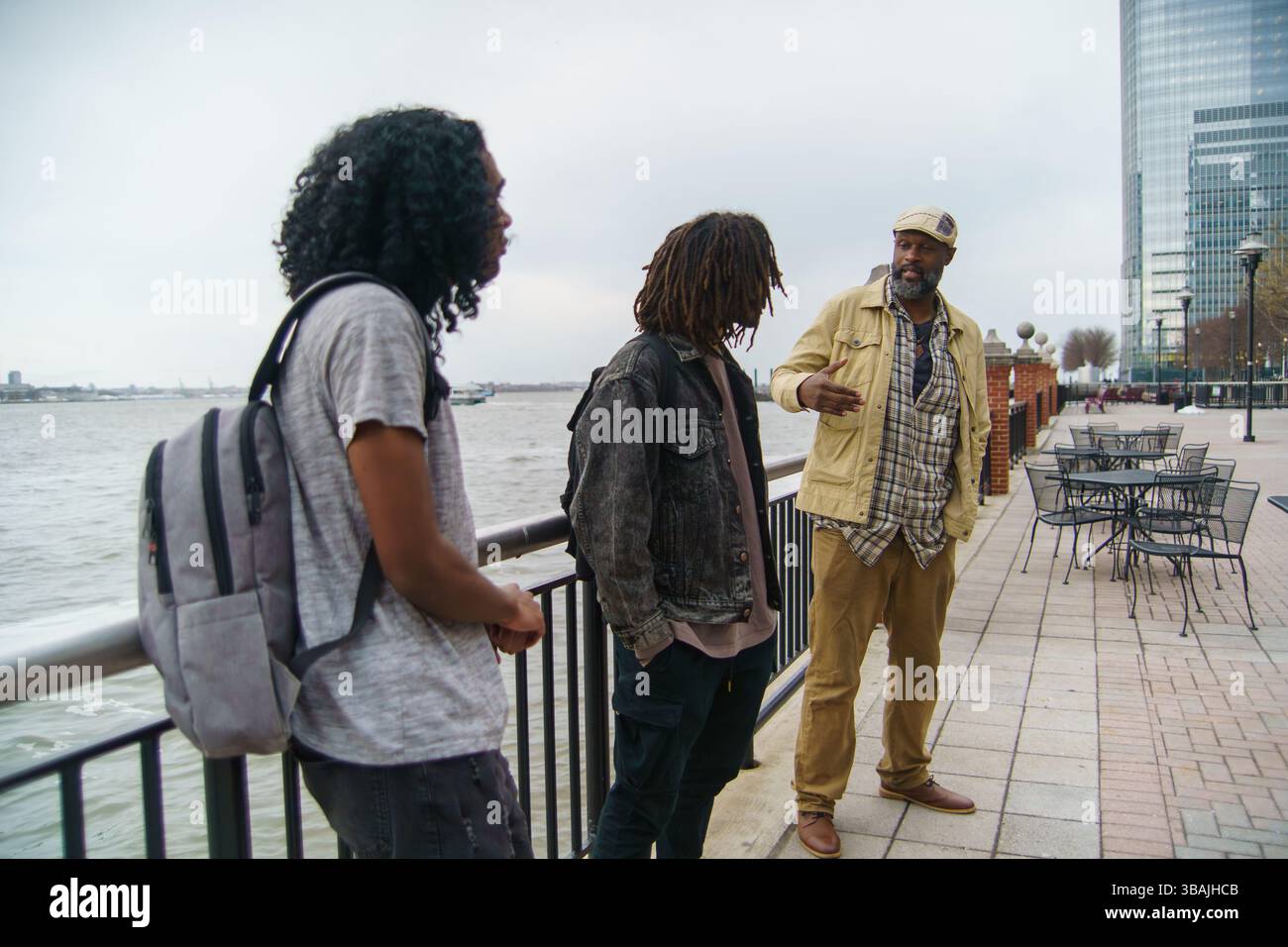 Middle-aged Black man in beret hat having conversation with mixed race ...