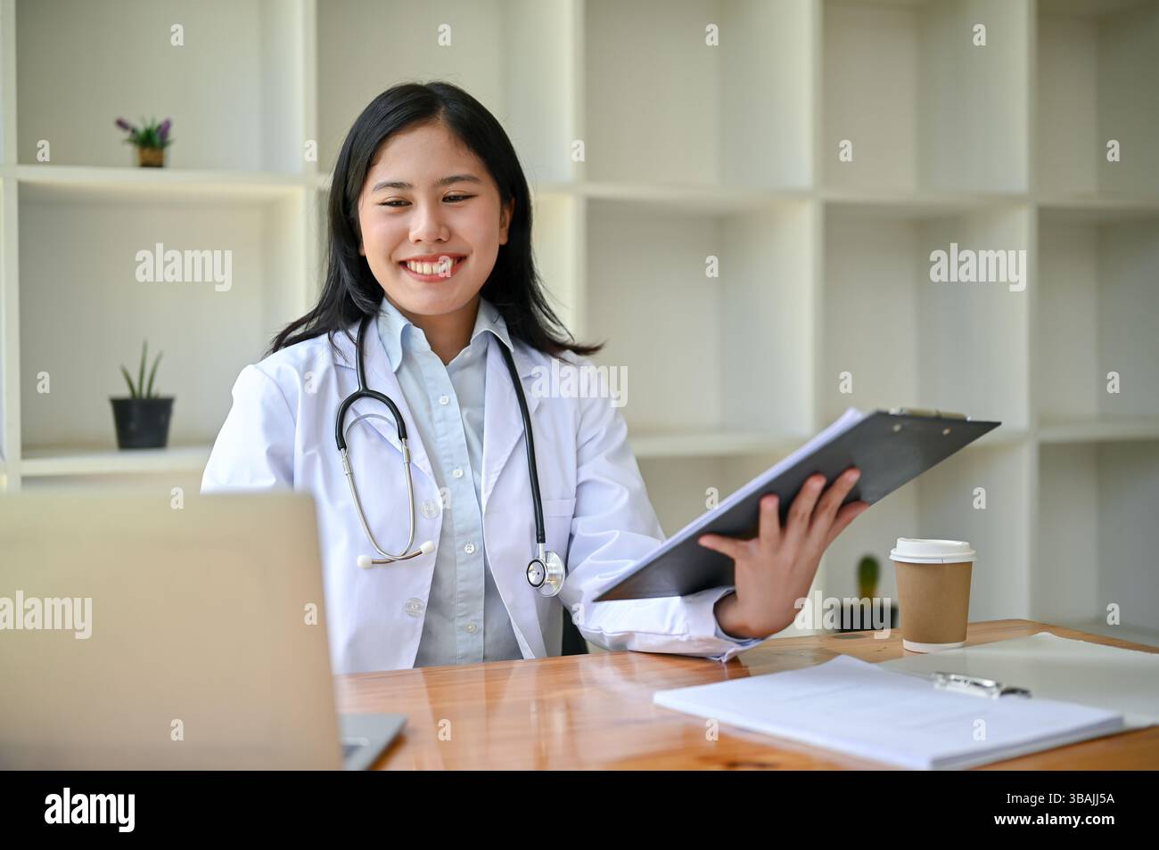 A portrait of a professional and happy young Asian female doctor ...