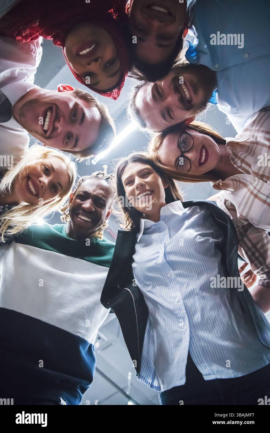 Cheerful diverse group of startup business team standing in circle with ...